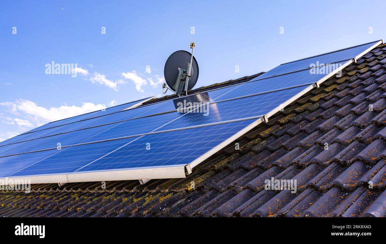 Private photovoltaic system with solar panels on a house roof with roof ...