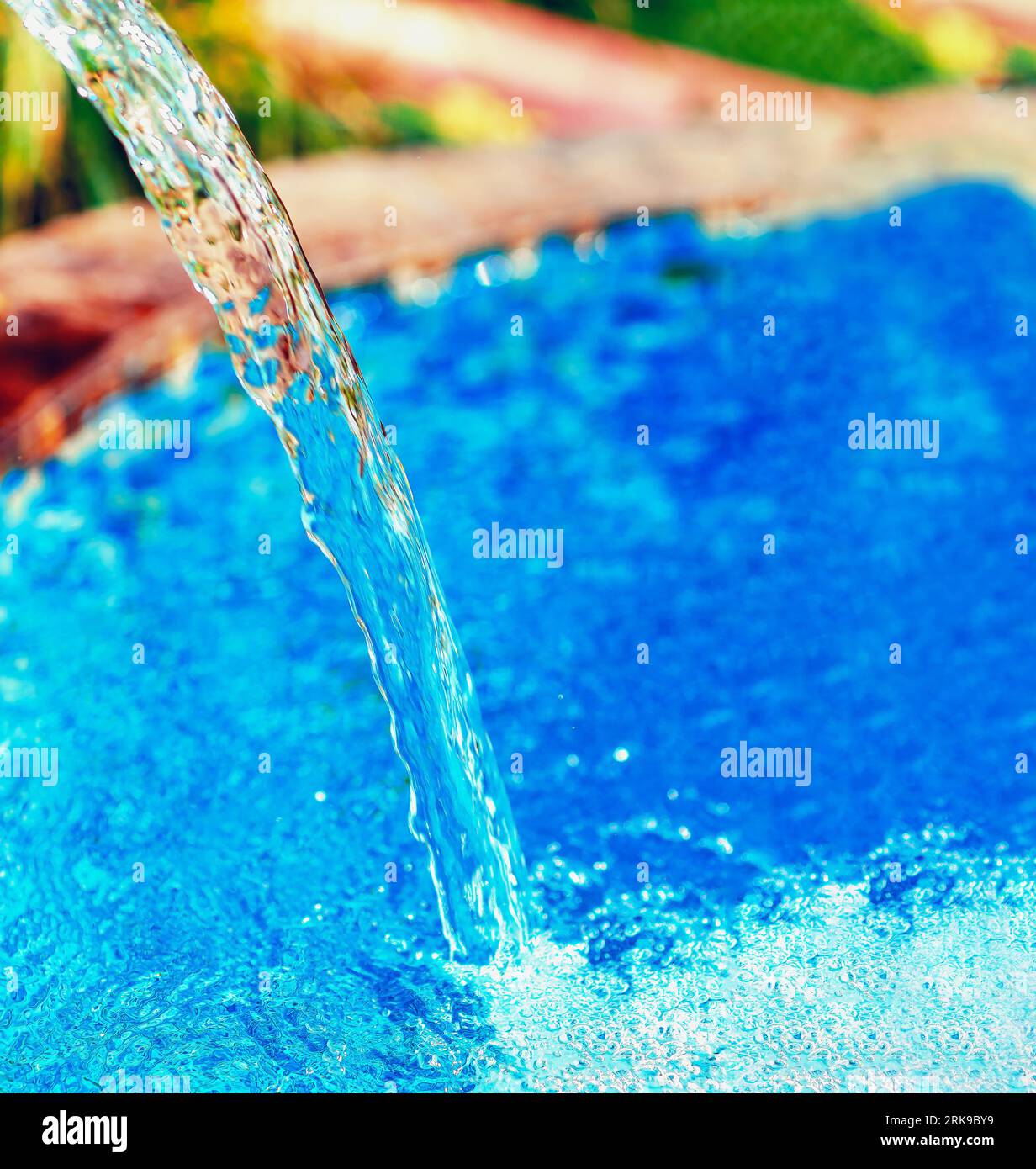 A stream of water flows into the pool. Blue water Stock Photo - Alamy
