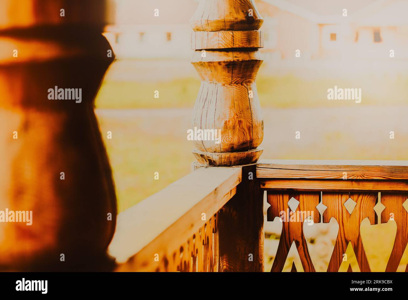 A wooden carved balcony of a rural house on a sunny day. It captures ...