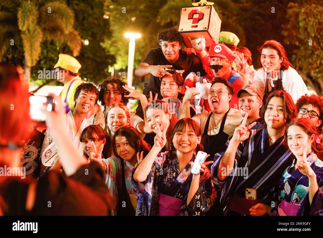 Crowd members pose for photographs at the culmination of the Japan Bon ...