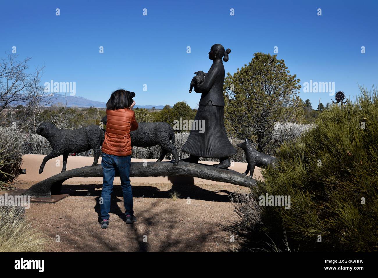 A tourist takes a photograph of a bronze sculpture by renowned ...