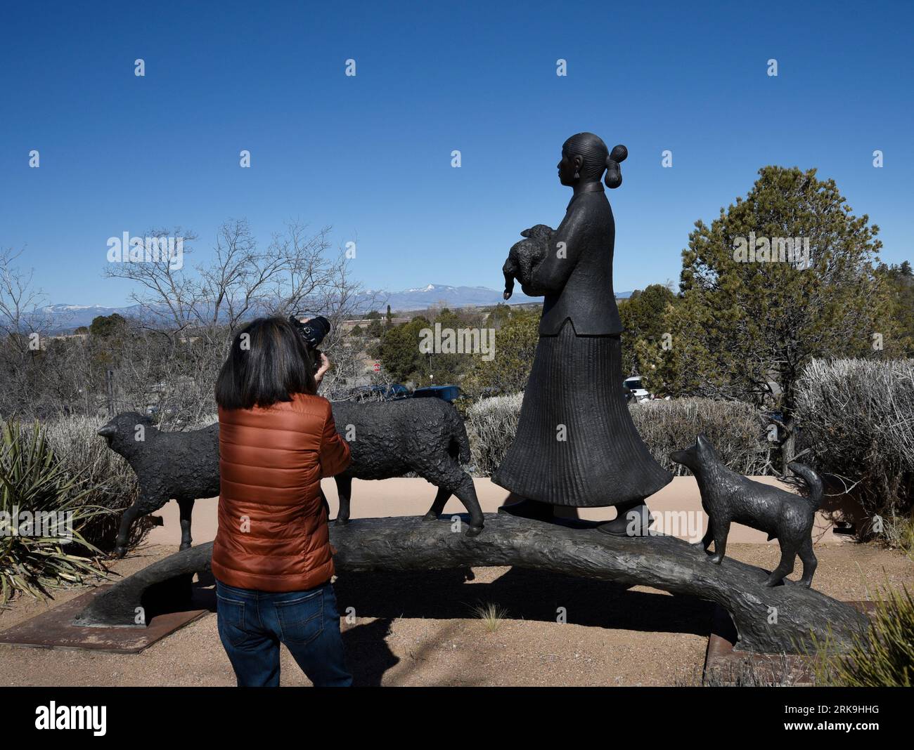 A tourist takes a photograph of a bronze sculpture by renowned ...