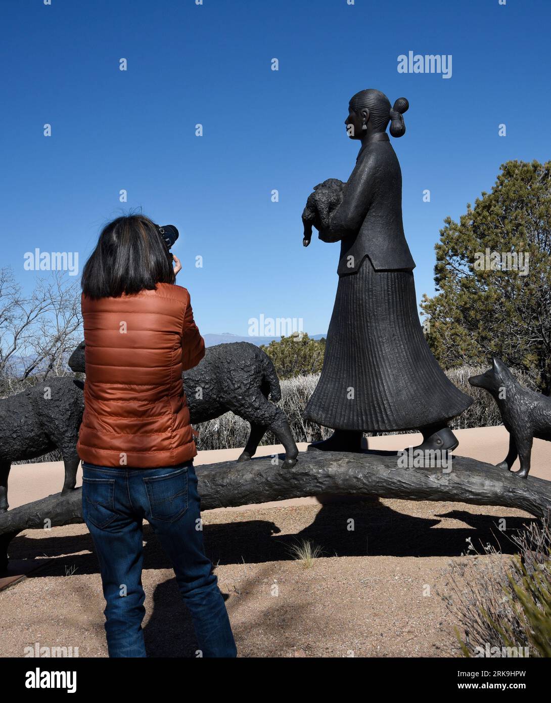A tourist takes a photograph of a bronze sculpture by renowned ...