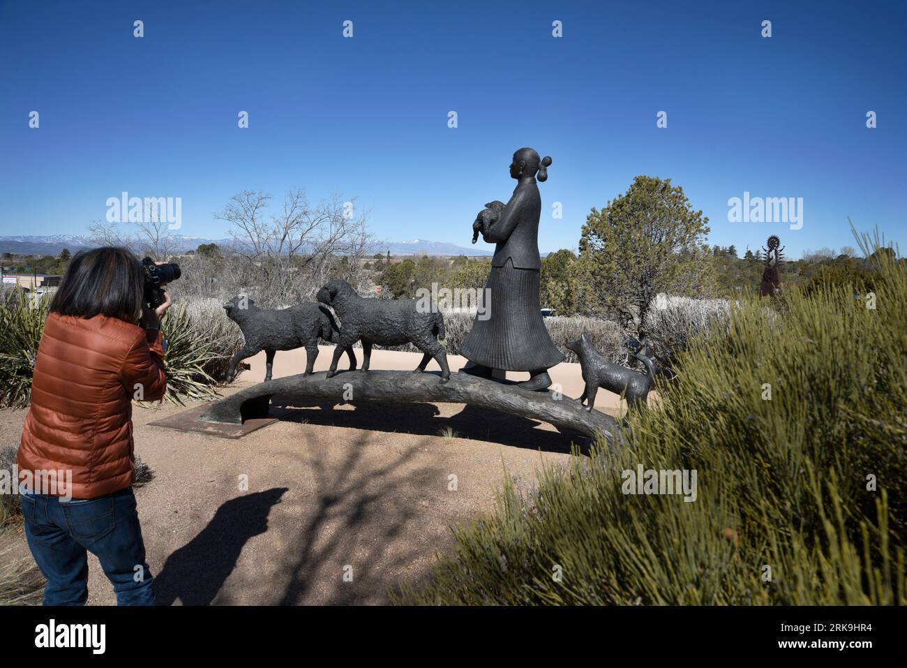 A tourist takes a photograph of a bronze sculpture by renowned ...