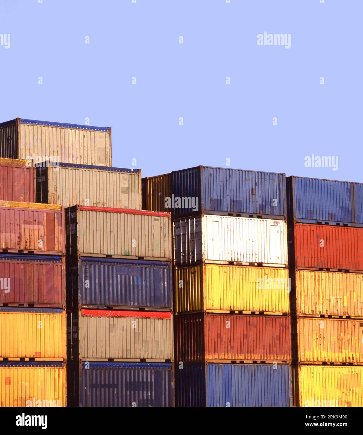 Stacked multi color cargo containers with clear blue sky. No names on ...