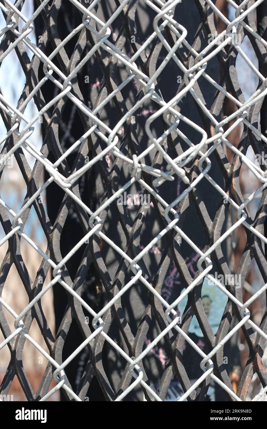 A typical metal chain link fence with a repeating pattern of steel ...