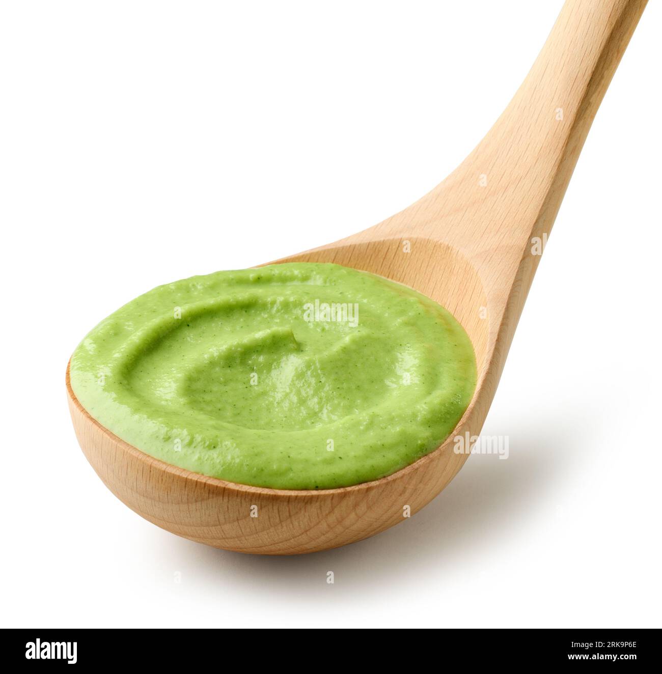 green vegetable cream soup in wooden ladle isolated on white background ...
