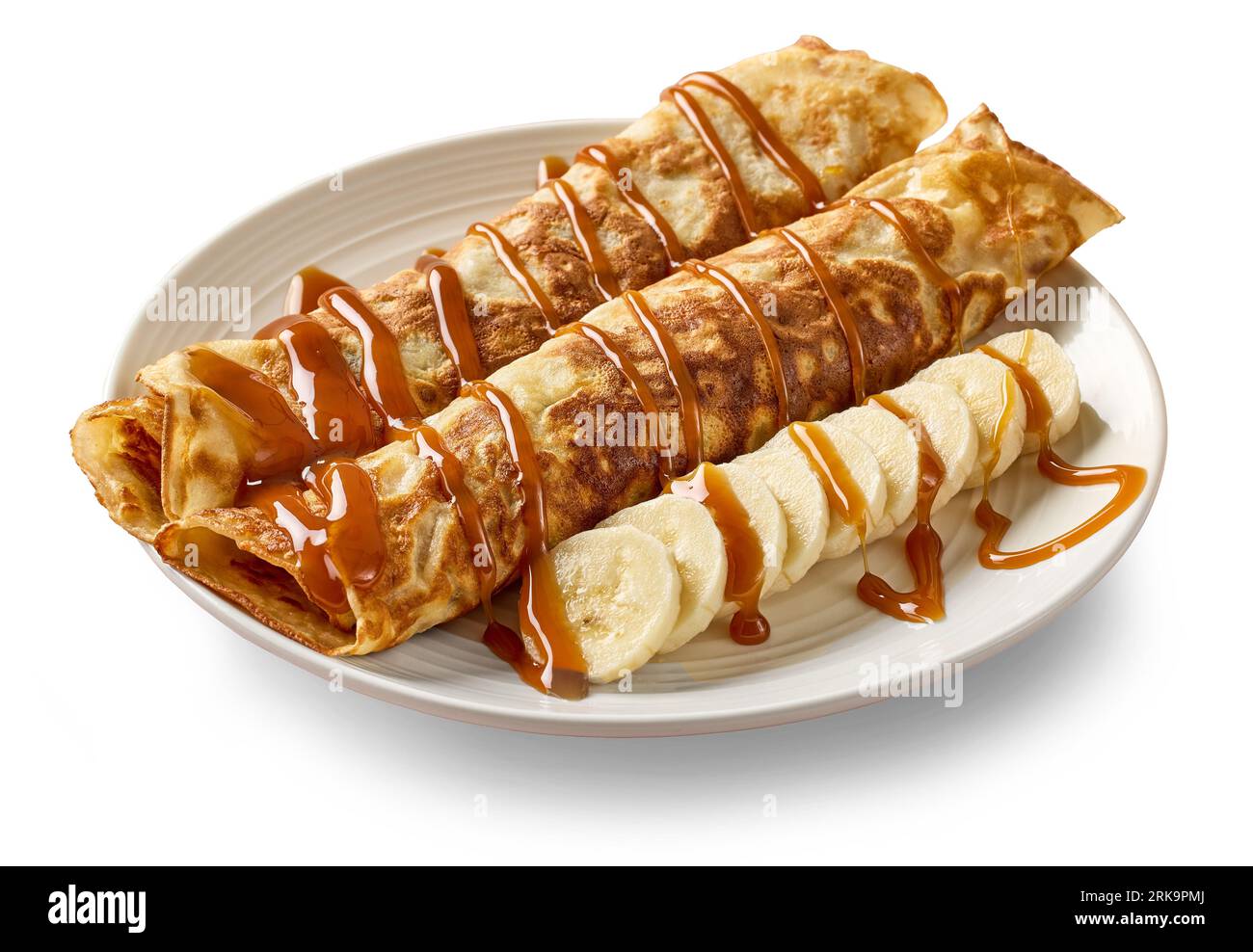 freshly baked crepes with banana and melted caramel sauce on plate ...