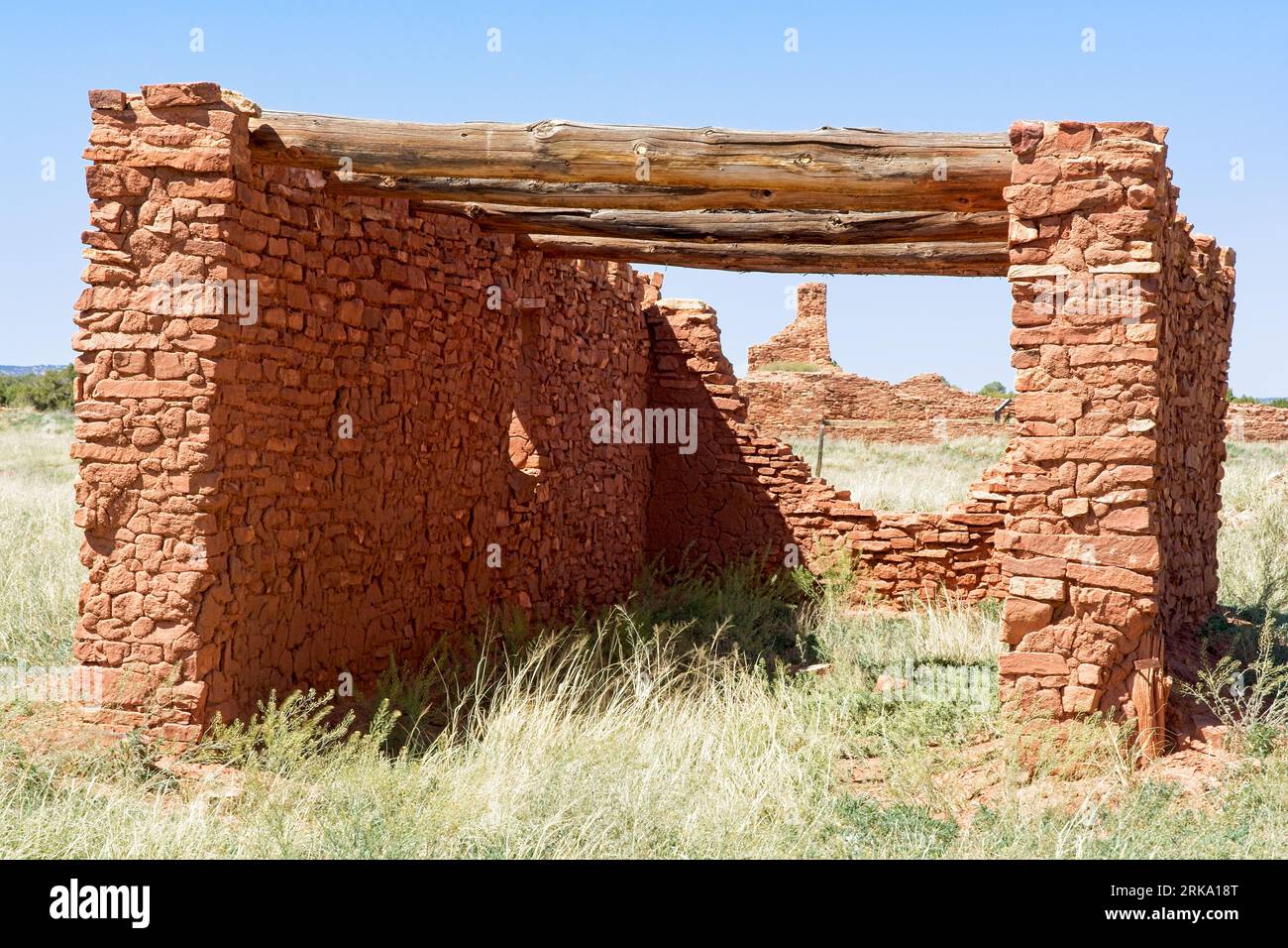Looking through sandstone masonry pueblo ruins with roof vigas to San ...