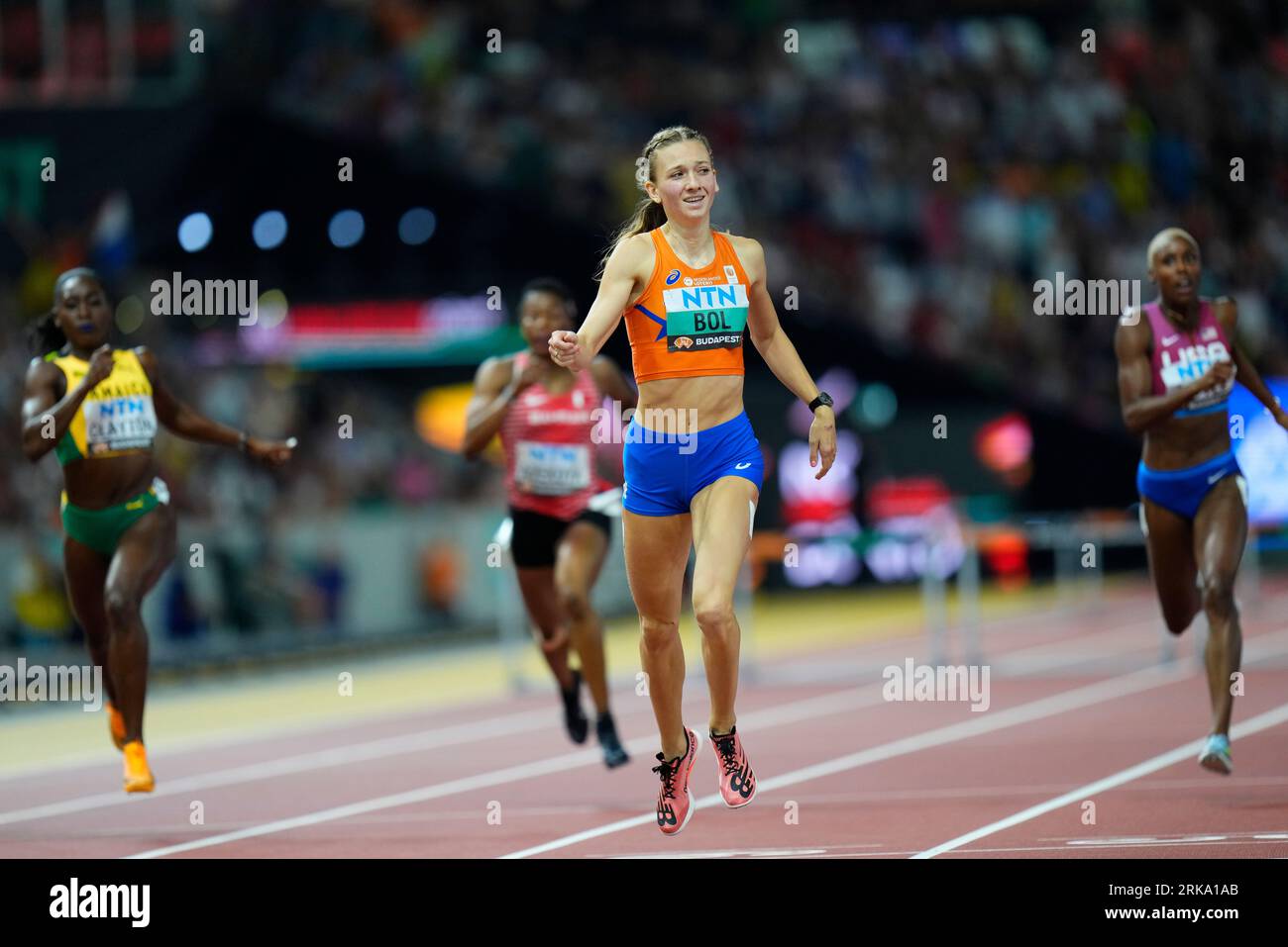 Femke Bol, of the Netherlands, center, crosses the line to win the gold ...