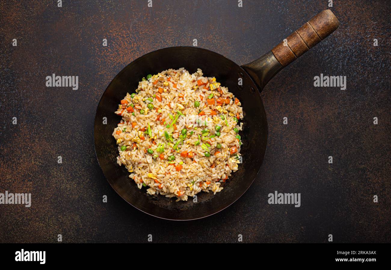 Authentic Chinese and Asian fried rice with egg and vegetables in wok ...