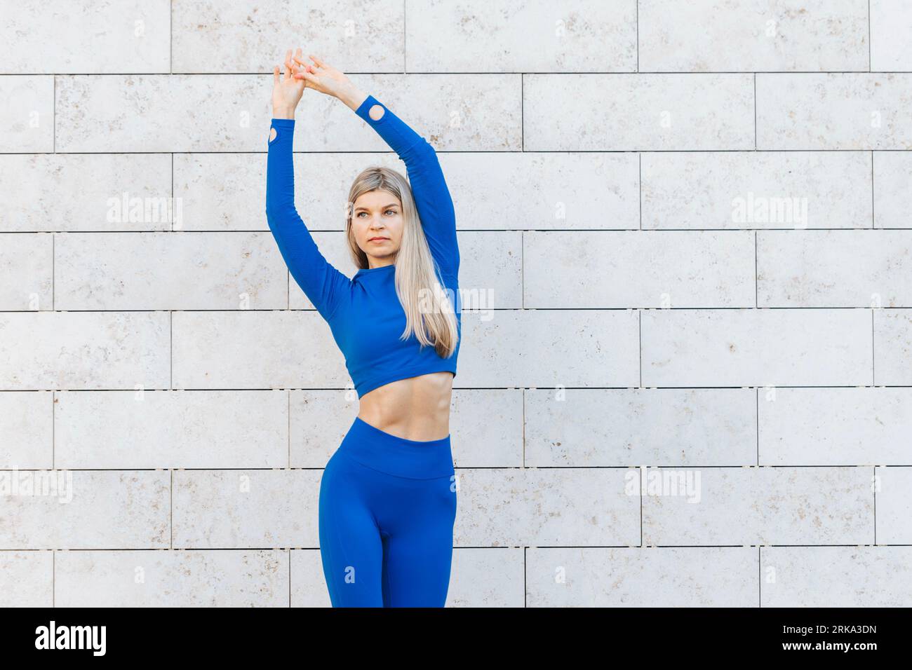 Fitness sport woman doing stretching exercise over gray wall ...