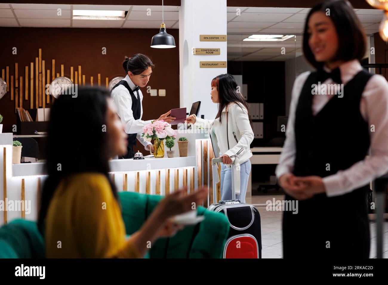 Male front desk receptionist at luxury resort checking visitors ...