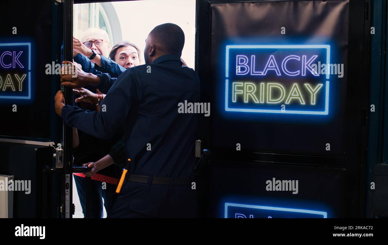 Security guard keeping people in check before opening clothing store on ...