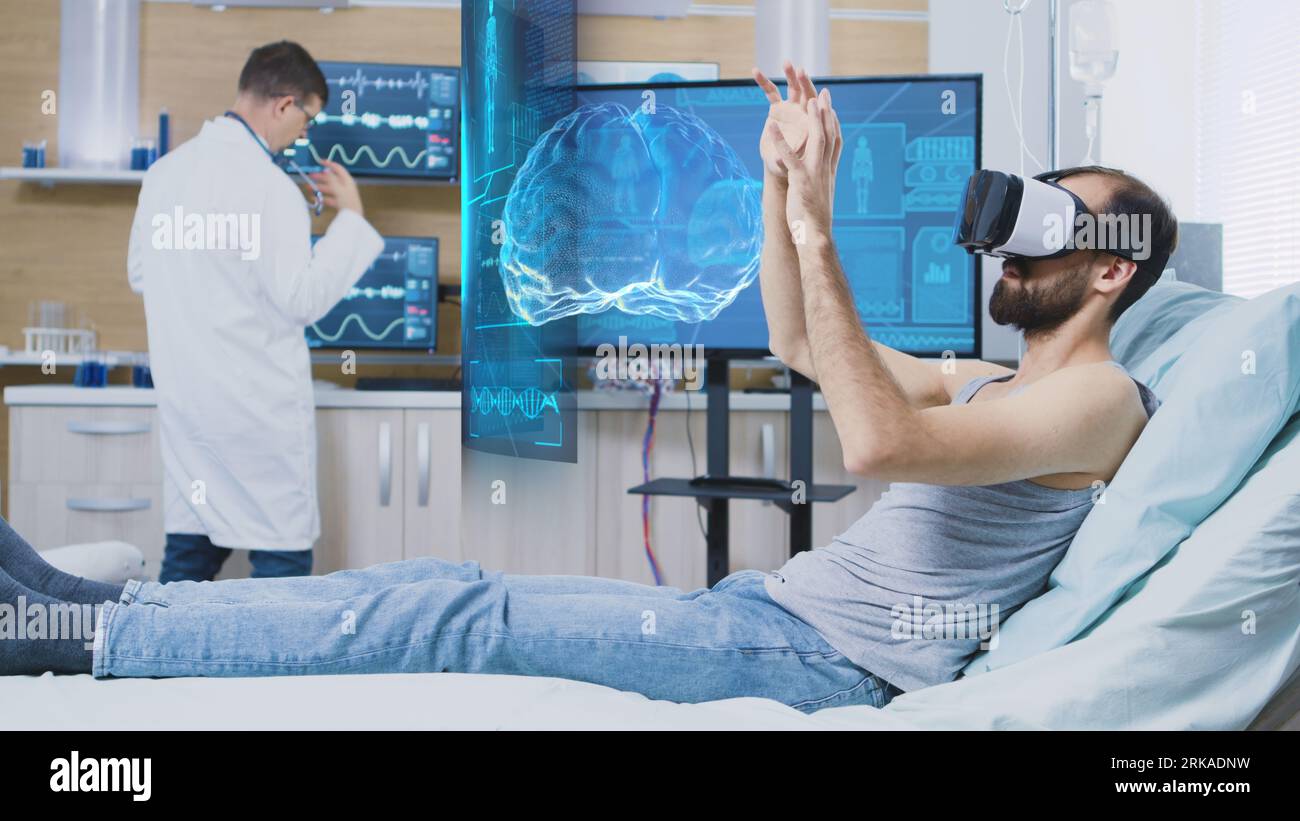 Patient laying in clinic bed wearing virtual reality headset while ...