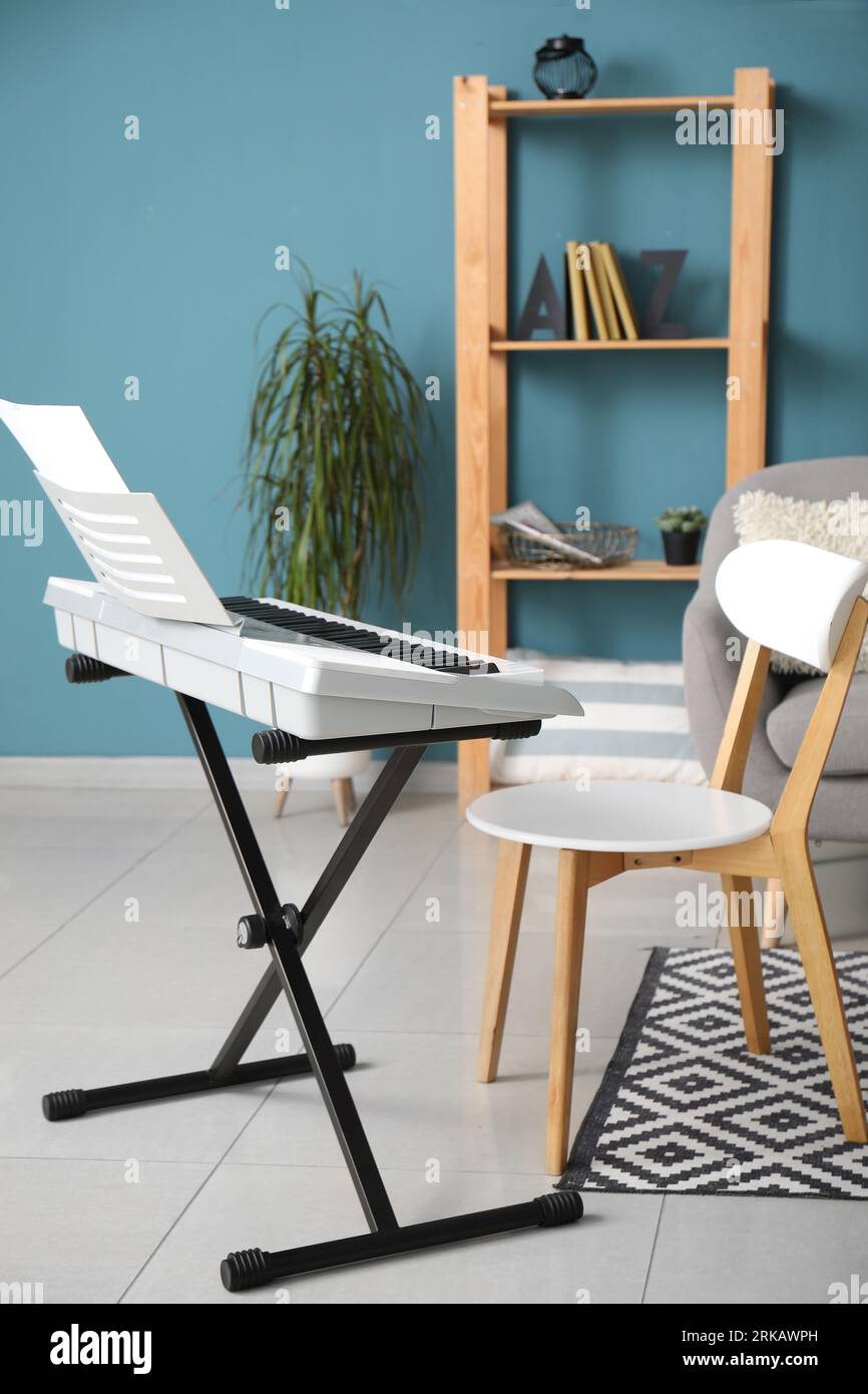 Modern synthesizer and chair in room Stock Photo - Alamy