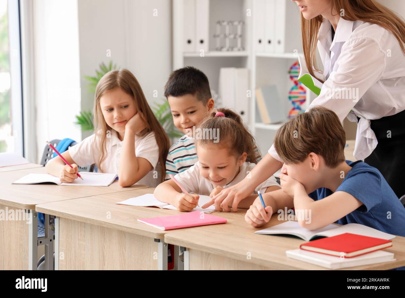 Little pupils having lesson with teacher in classroom Stock Photo - Alamy