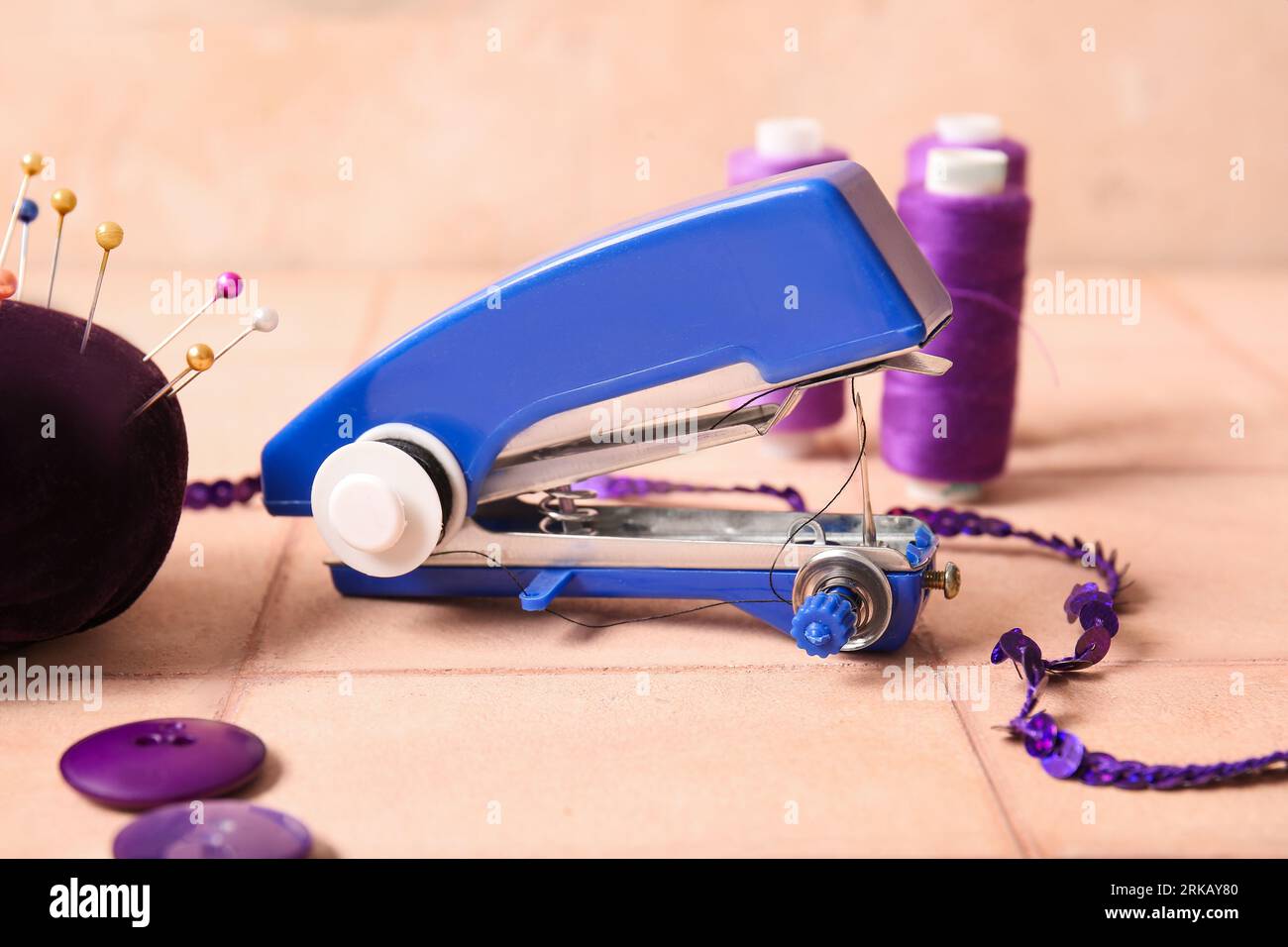 Female hand with different supplies and manual sewing machine on pink ...