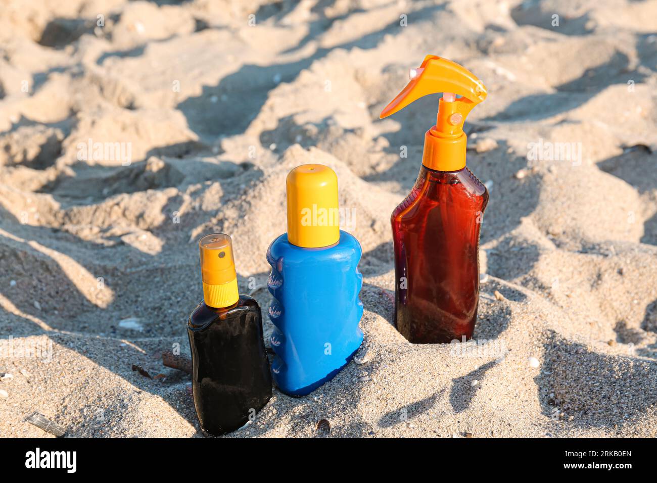 Bottles of sunscreen cream on sand at beach Stock Photo - Alamy