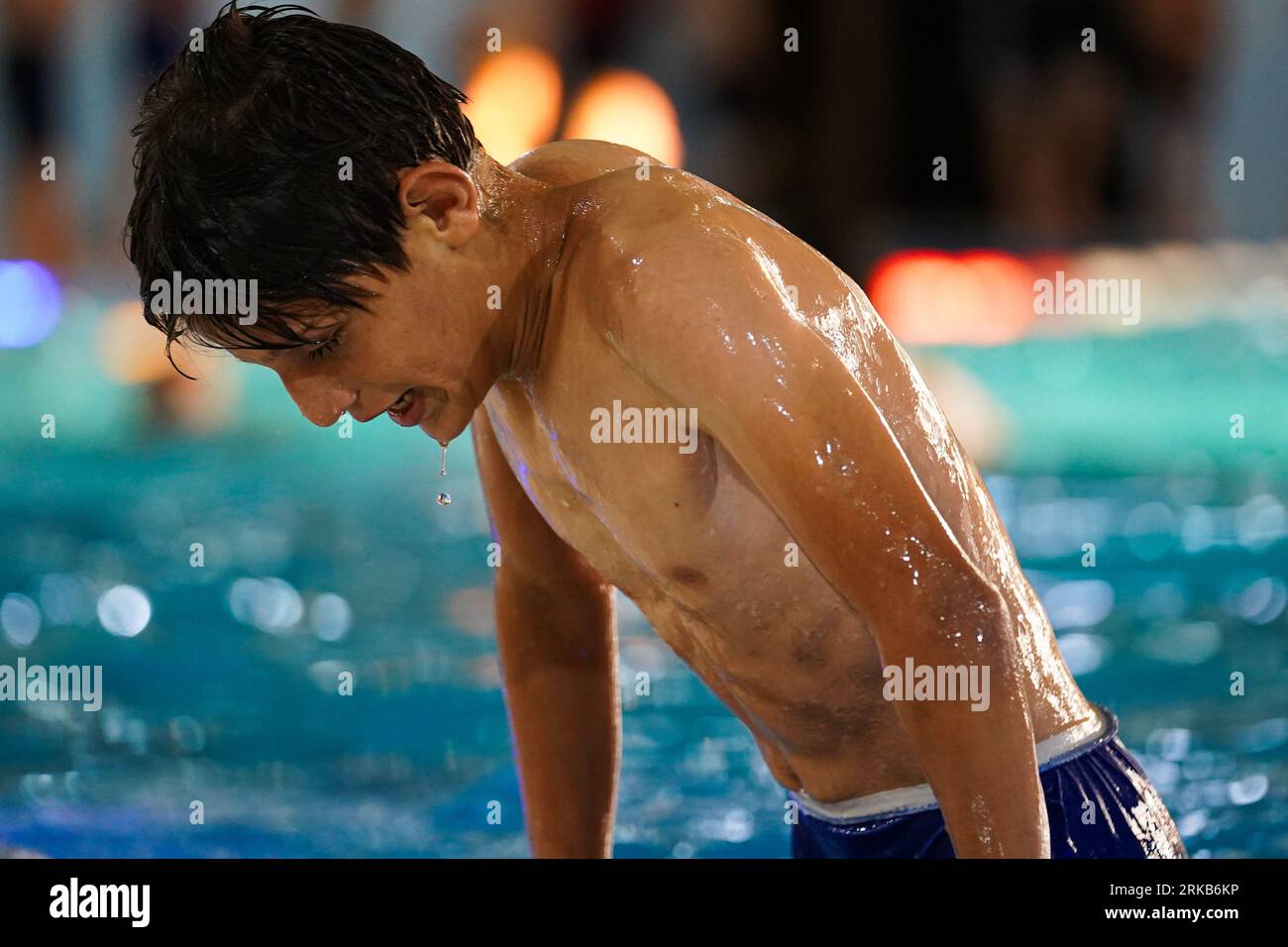 A young man cools himself in a swimming pool on a hot summer day. In ...