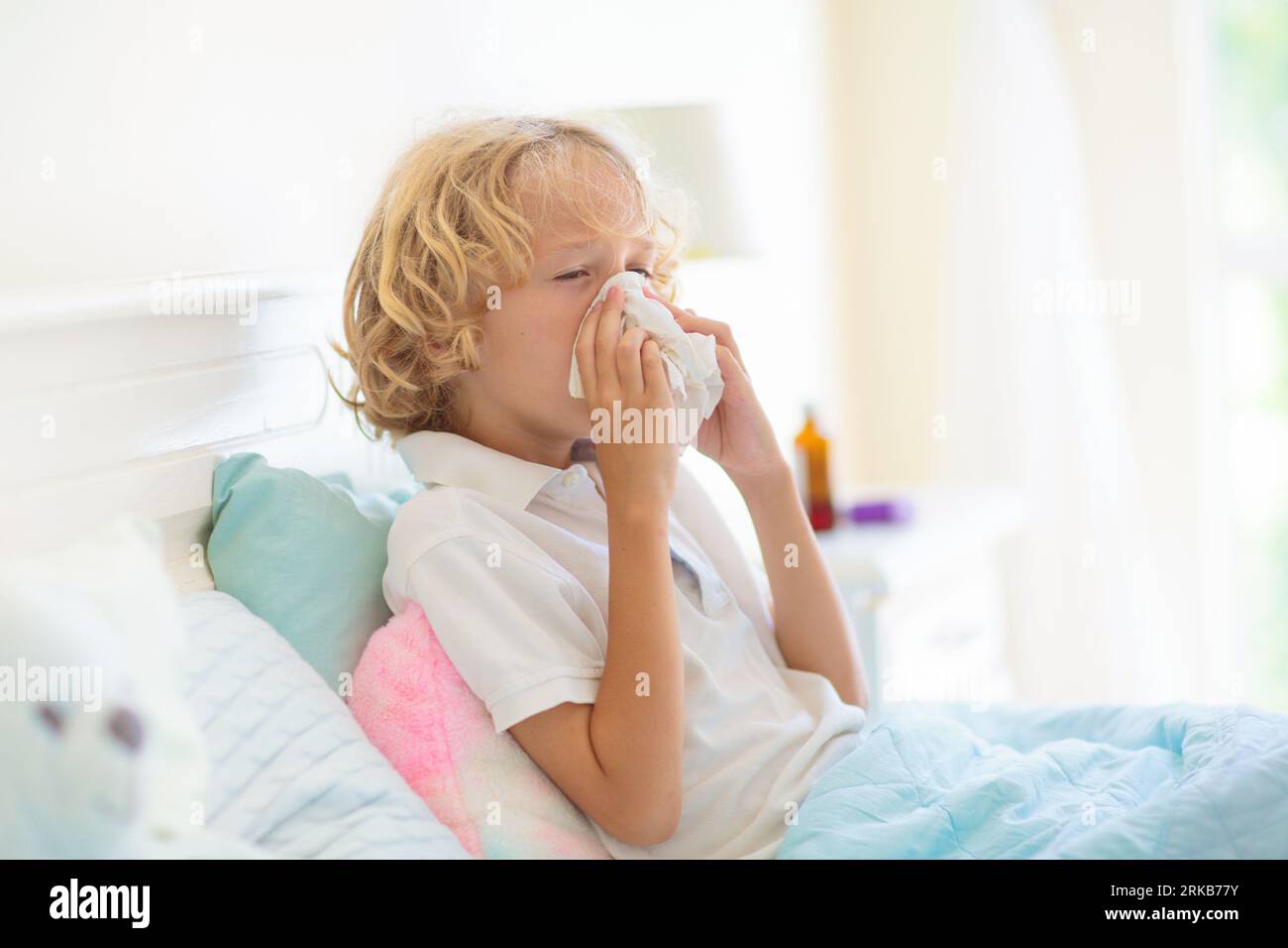 Sick child in bed. Mother checking on unwell kid. Little boy having fever feeling ill. Mom with ...