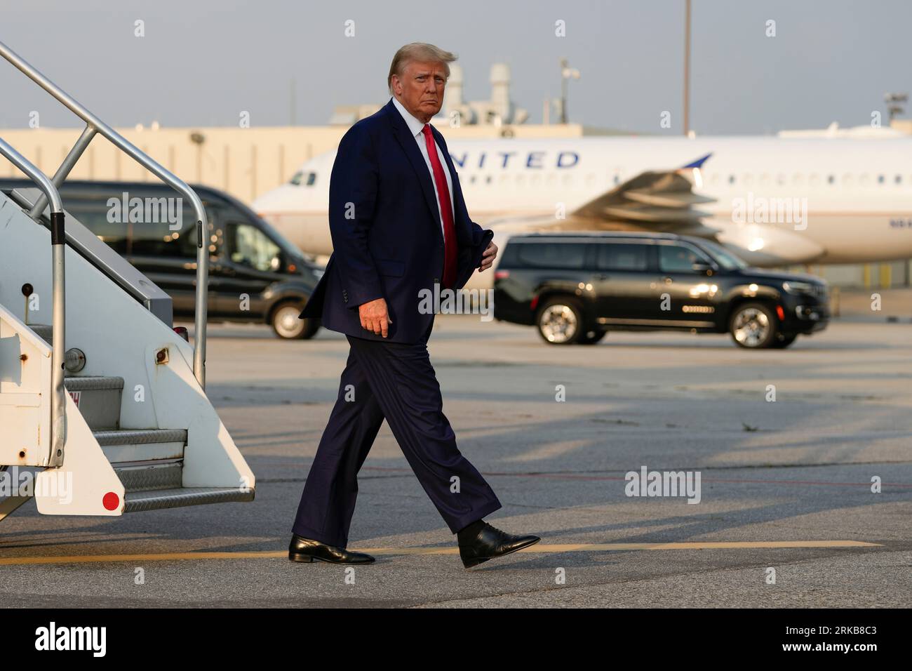 Former President Donald Trump steps off his plane as he arrives at ...