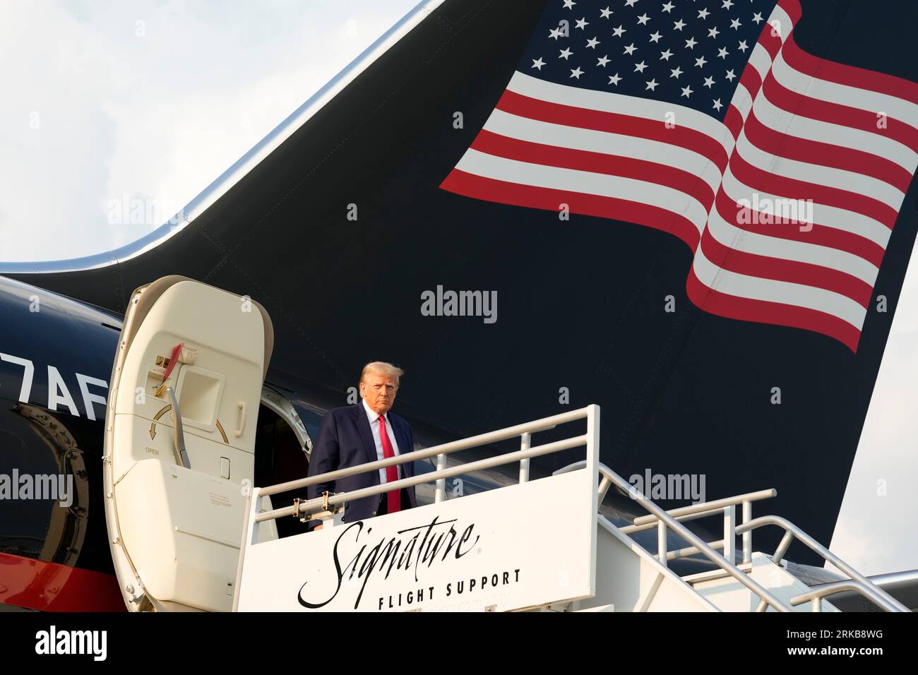Former President Donald Trump steps off his plane as he arrives at ...