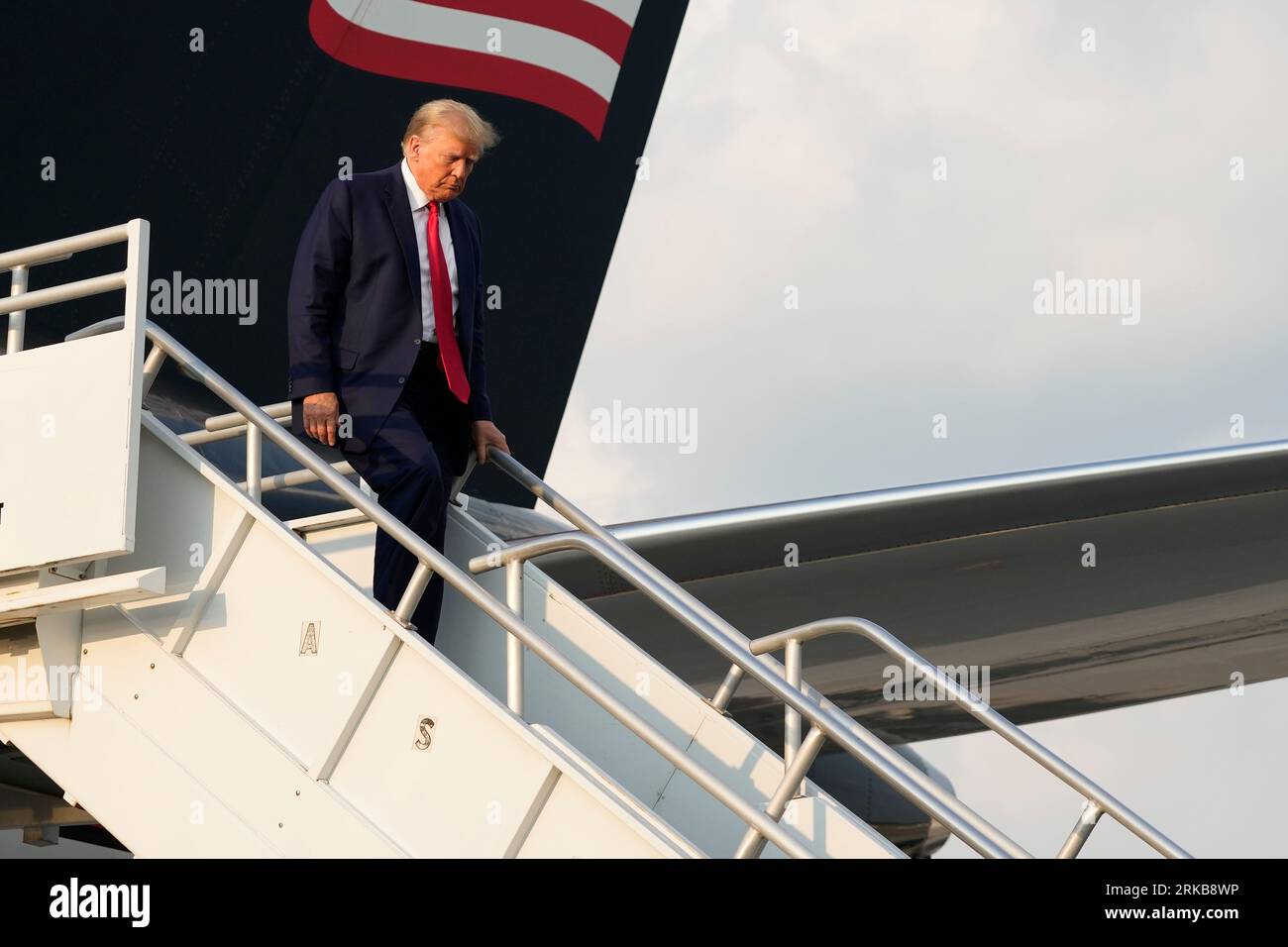 Former President Donald Trump steps off his plane as he arrives at ...