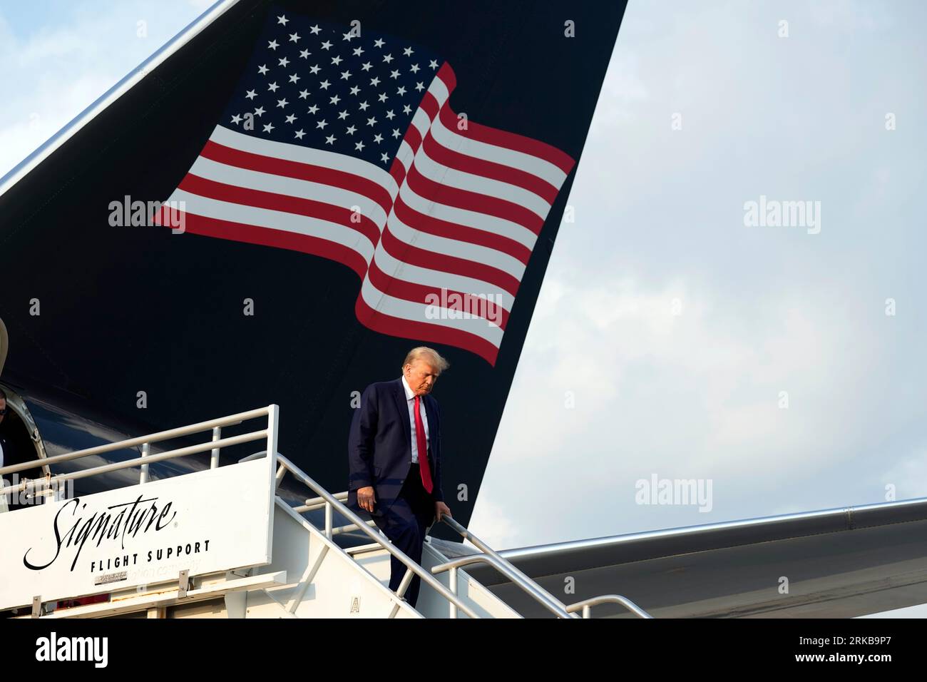 Former President Donald Trump steps off his plane as he arrives at ...