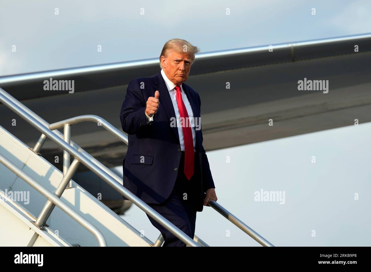 Former President Donald Trump steps off his plane as he arrives at ...