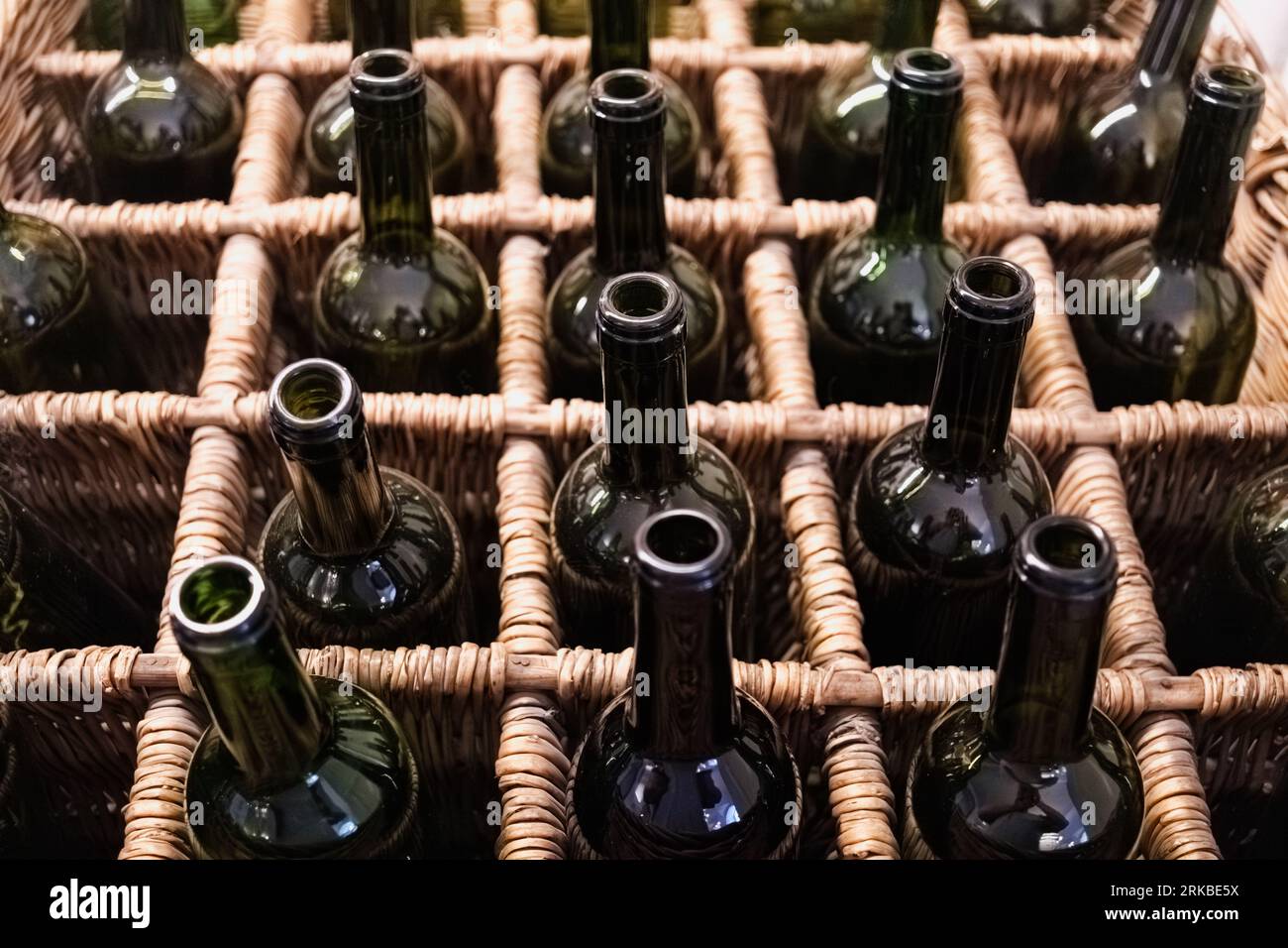Old empty wine bottles in a wicker basket Stock Photo - Alamy