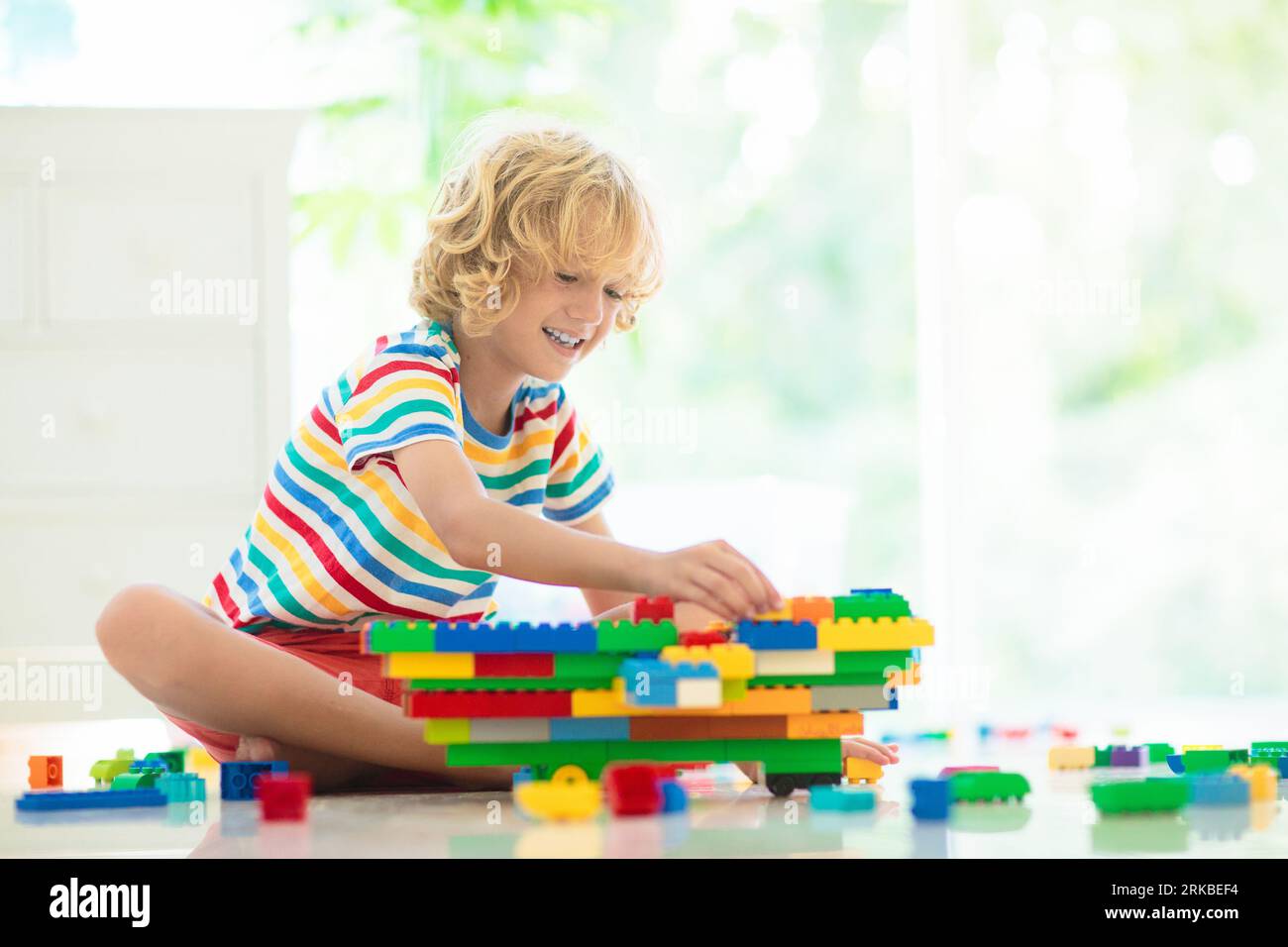 Kids play with colorful blocks. Little boy building tower at home or ...