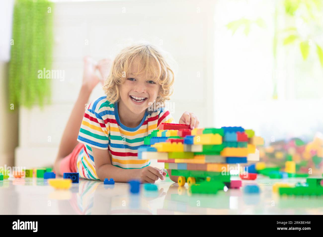 Kids play with colorful blocks. Little boy building tower at home or ...