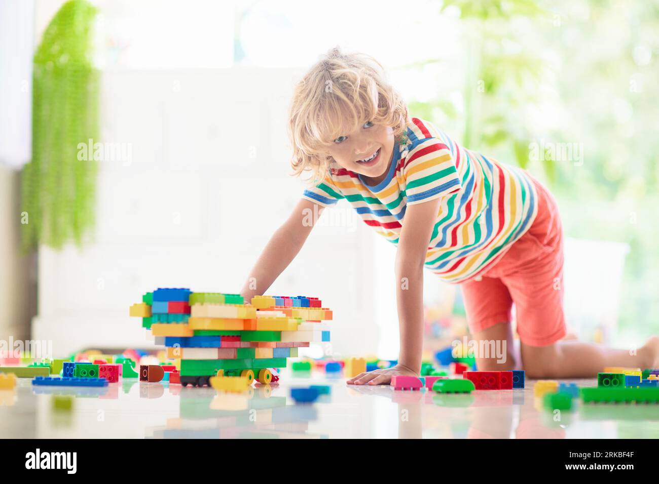 Kids play with colorful blocks. Little boy building tower at home or ...