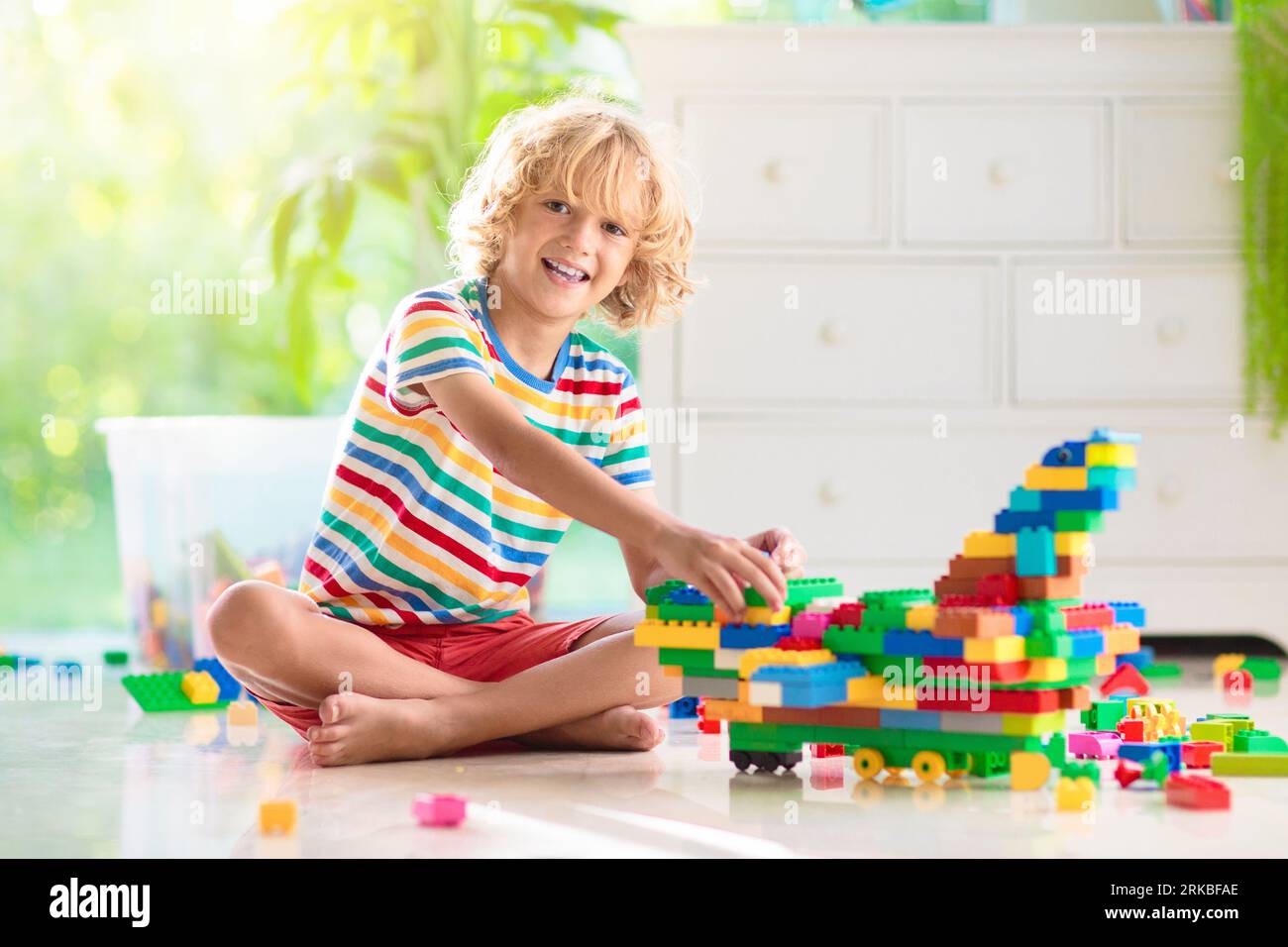 Kids play with colorful blocks. Little boy building tower at home or ...