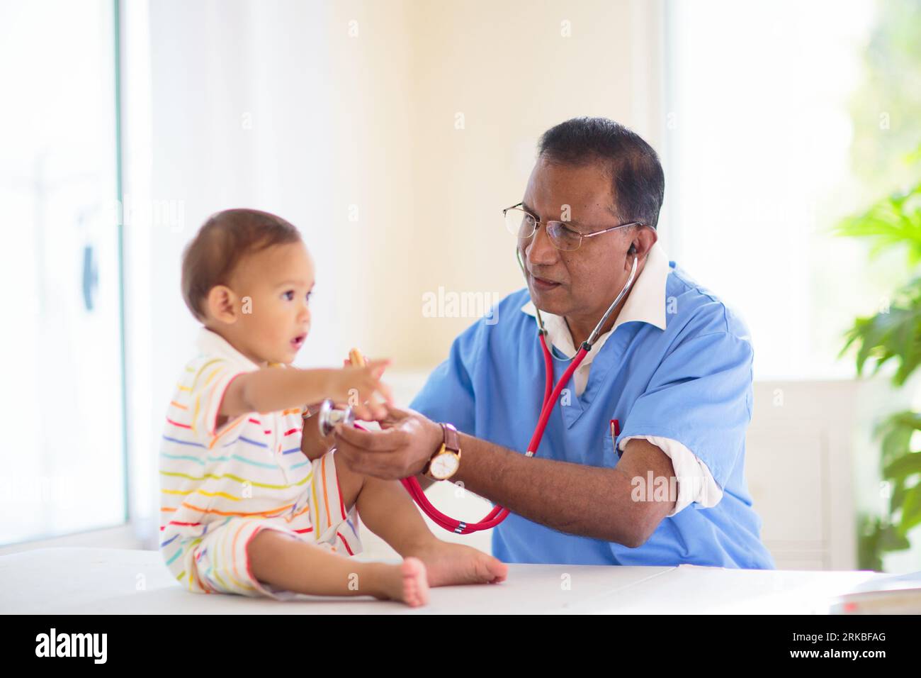Pediatrician doctor examining baby. Asian boy in health clinic for test ...