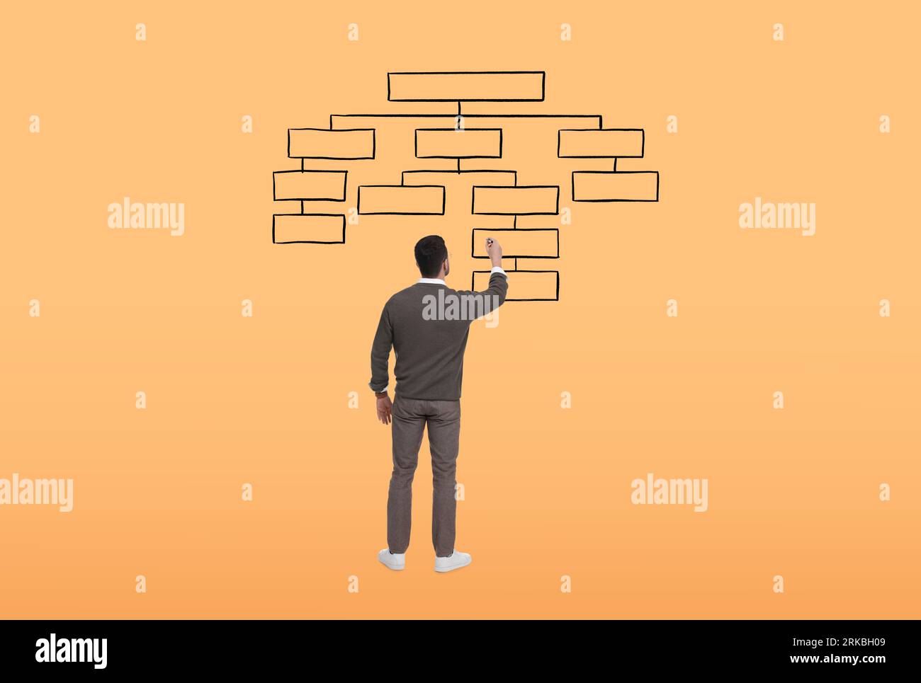Logic. Man filling block of diagram on pale orange background, back ...