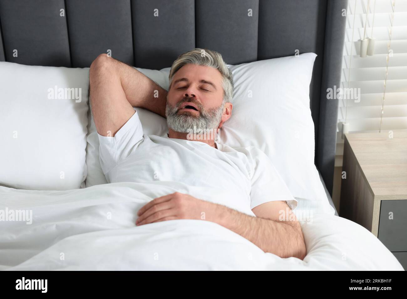 Man snoring while sleeping in bed at home Stock Photo - Alamy