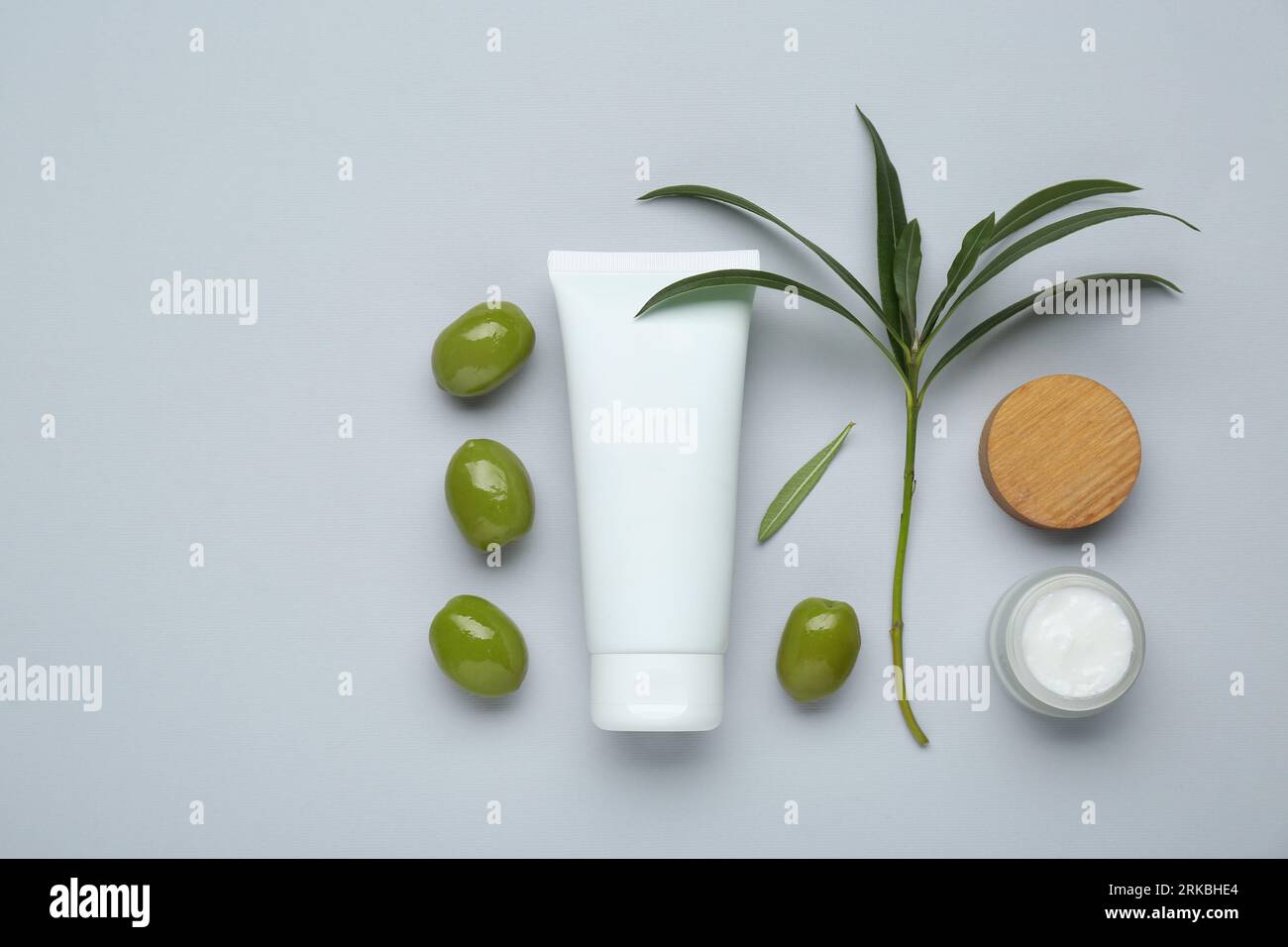 Cosmetic products with olive essential oil on light grey background ...