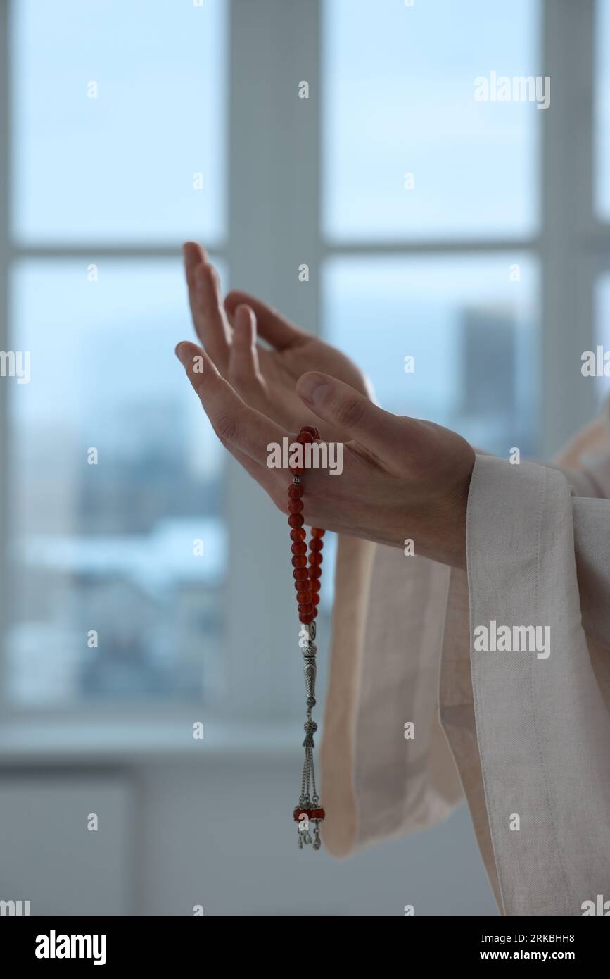 Muslim man with misbaha praying near window indoors, closeup Stock ...