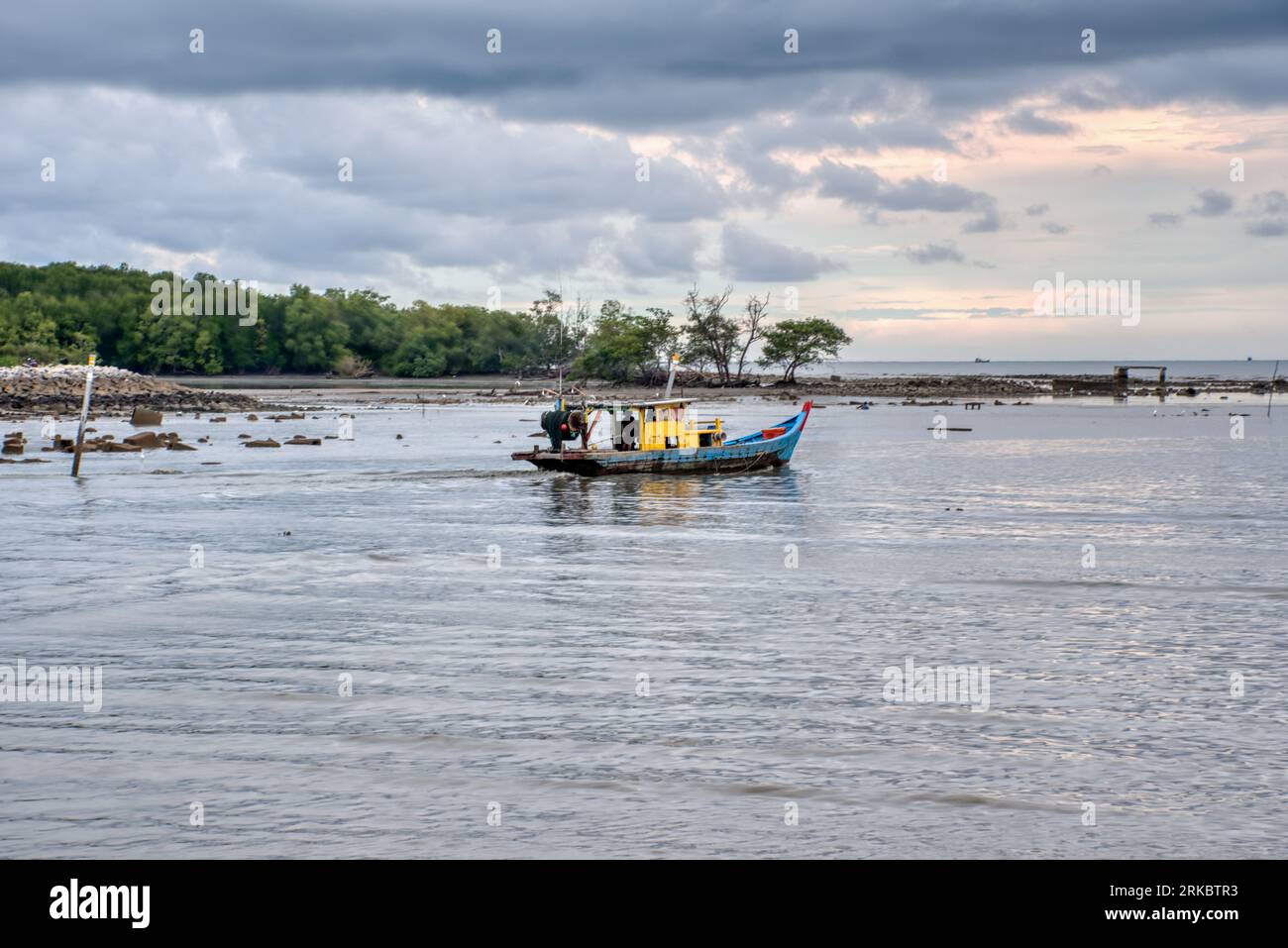 fishing boat sailing in the distance of the sea Stock Photo - Alamy