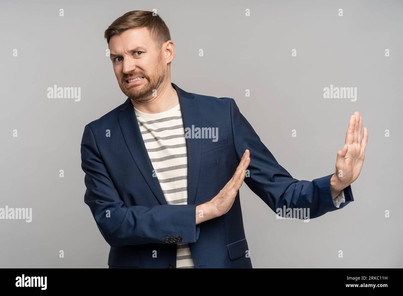 Man with disgust on face pushes negative space away from himself ...