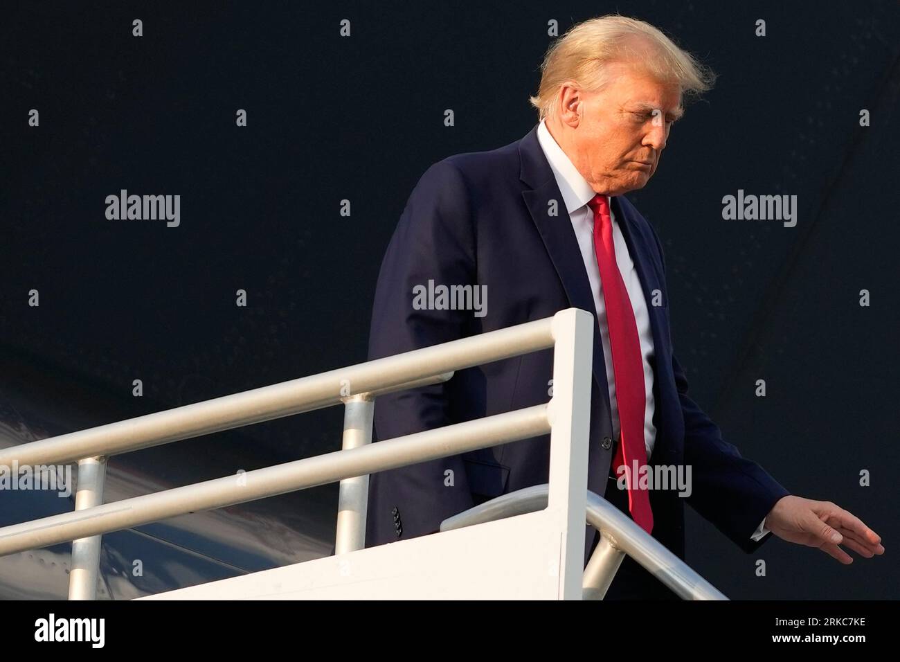 Former President Donald Trump steps off his plane as he arrives at ...