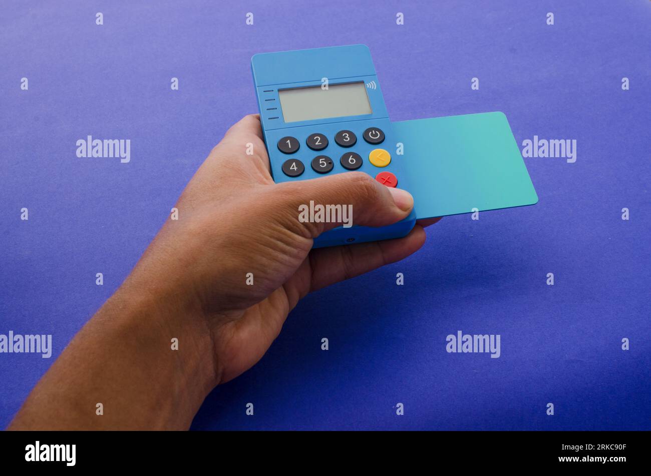 Hands holding a portable contactless payment device, An ultra-light and ...
