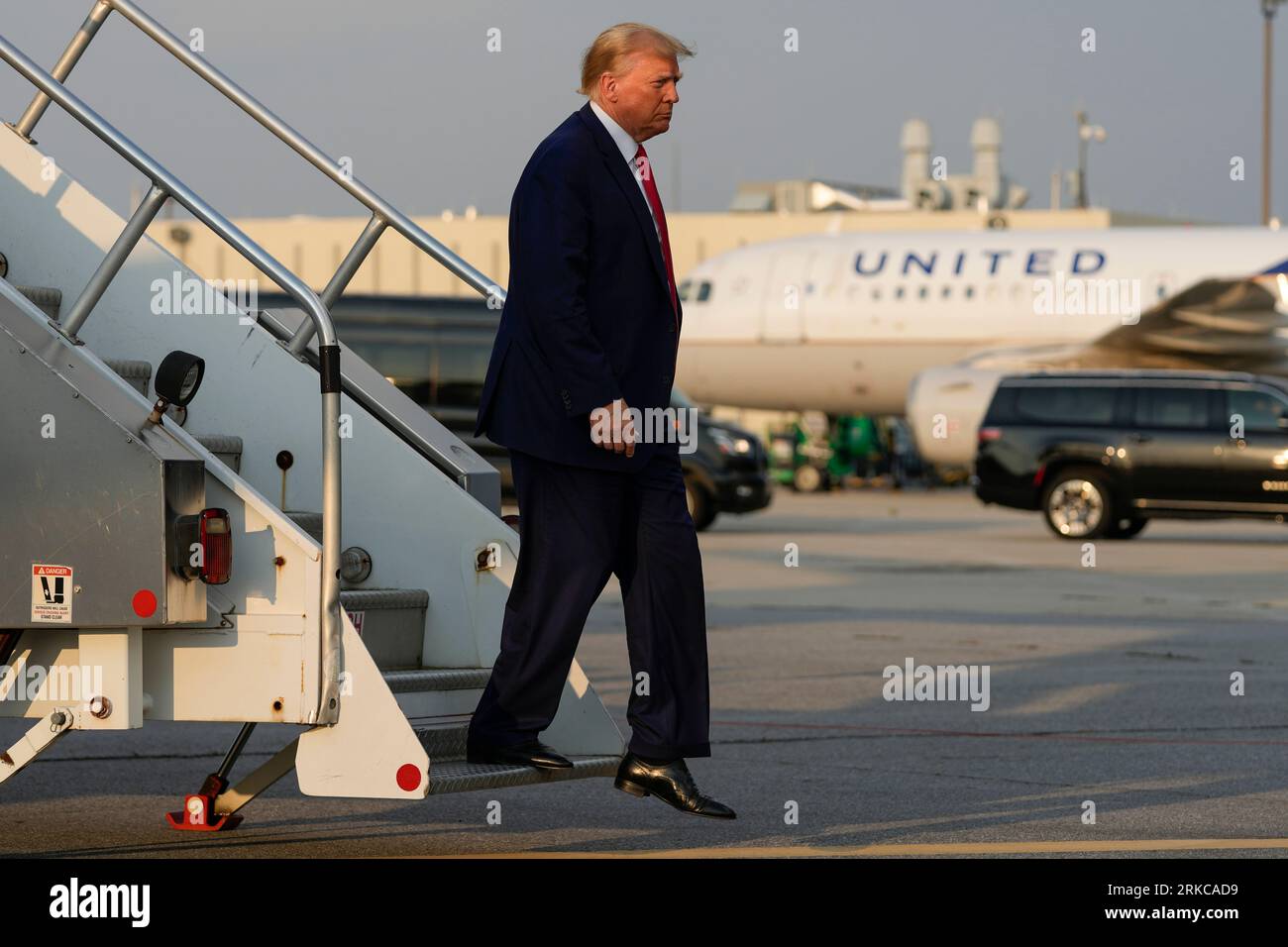 Former President Donald Trump steps off his plane as he arrives at ...