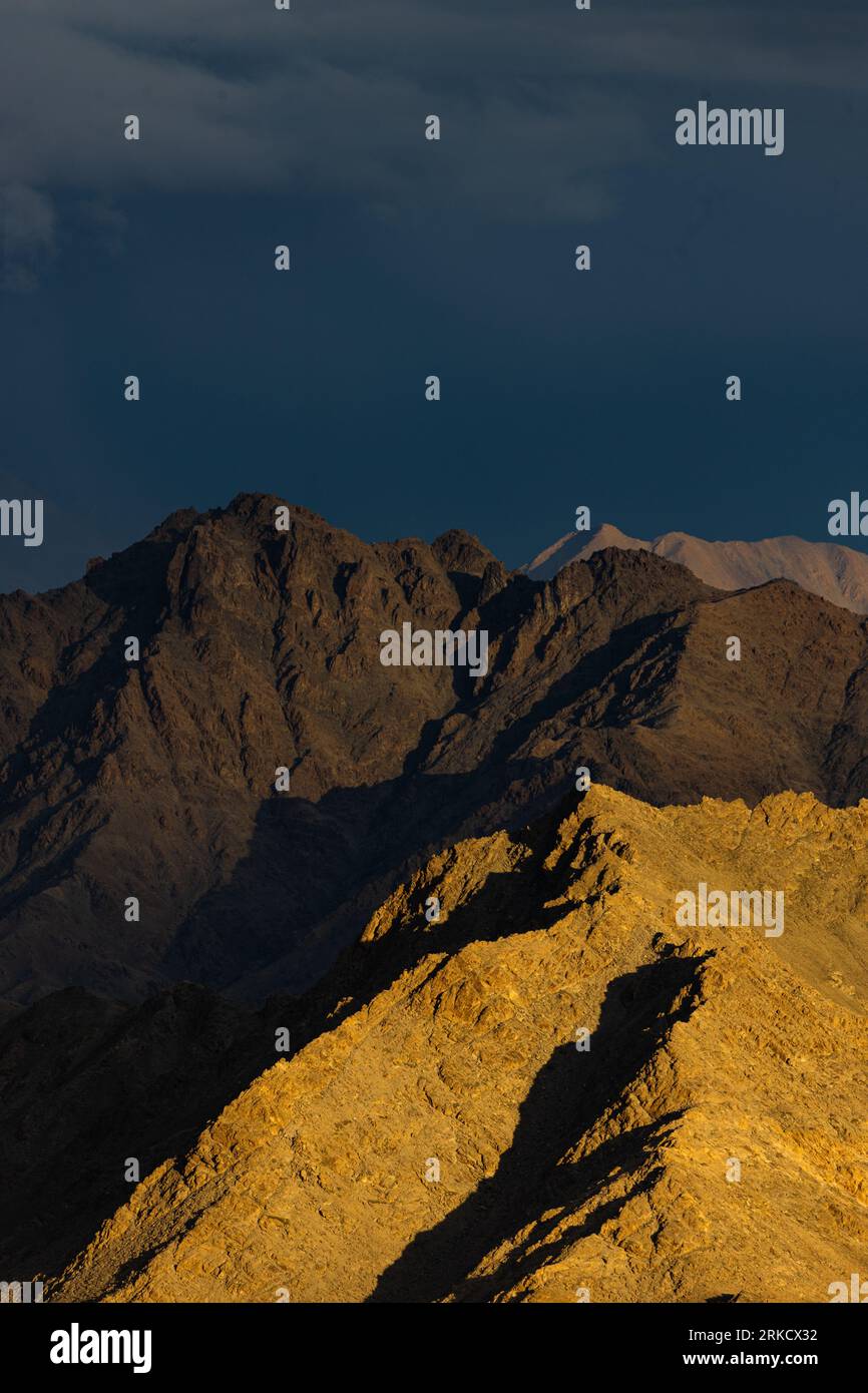 A panoramic landscape of light and shadows falling on mountains as fine ...