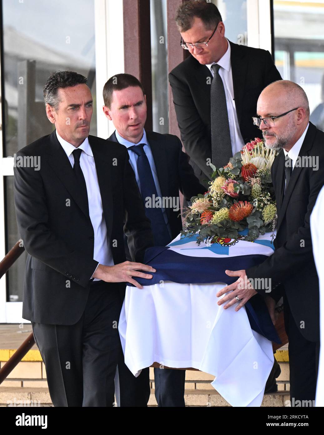 John Ahern (left), son of Mike Ahern and pallbearers are seen carrying ...