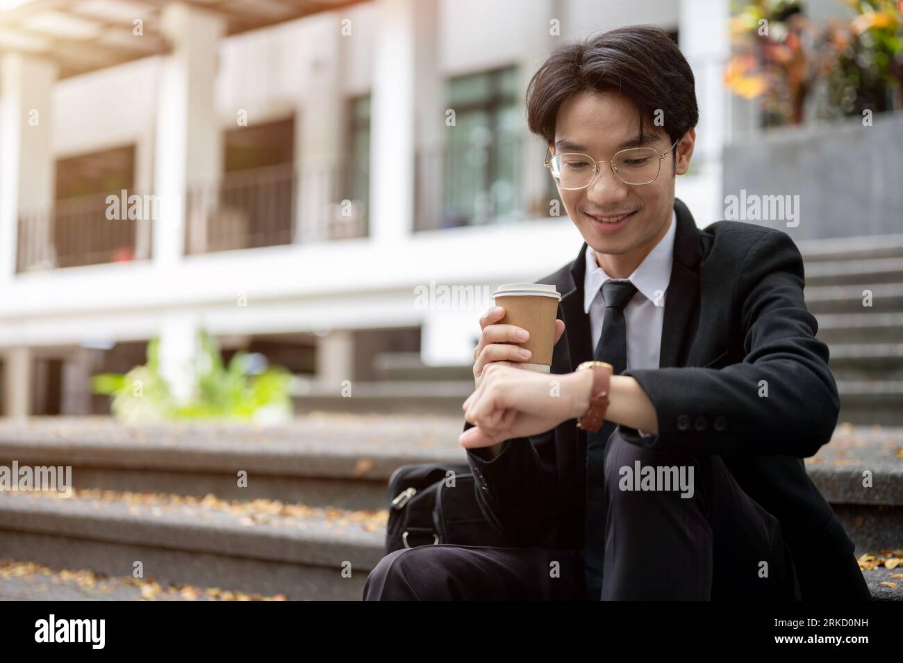 Businessman sitting checking watch smiling hi-res stock photography and ...