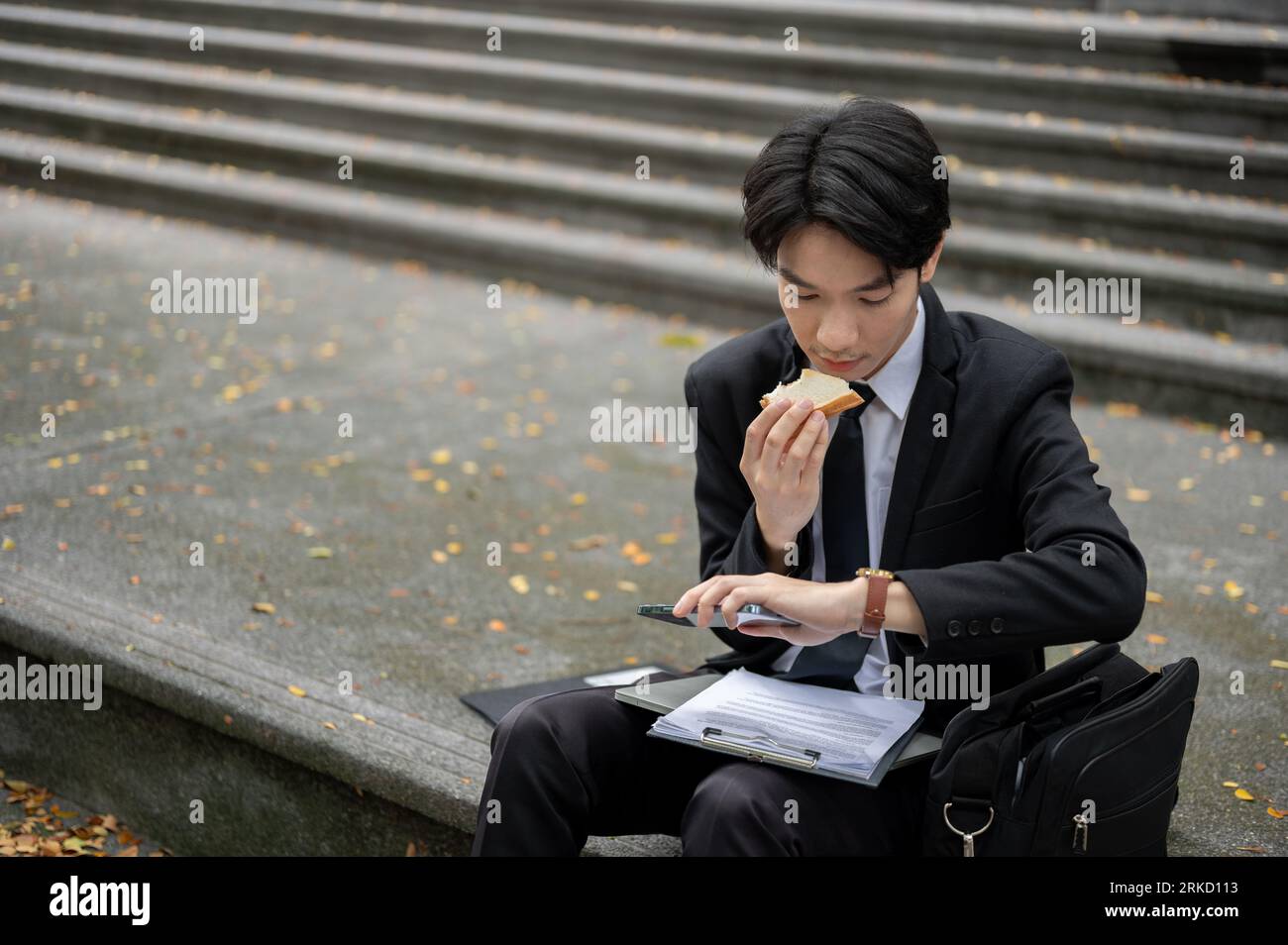 A busy and professional Asian businessman or male office worker is ...