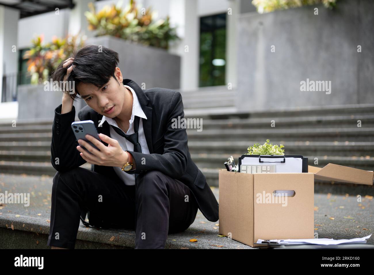 Stressed and upset young Asian businessman or male office worker typing ...